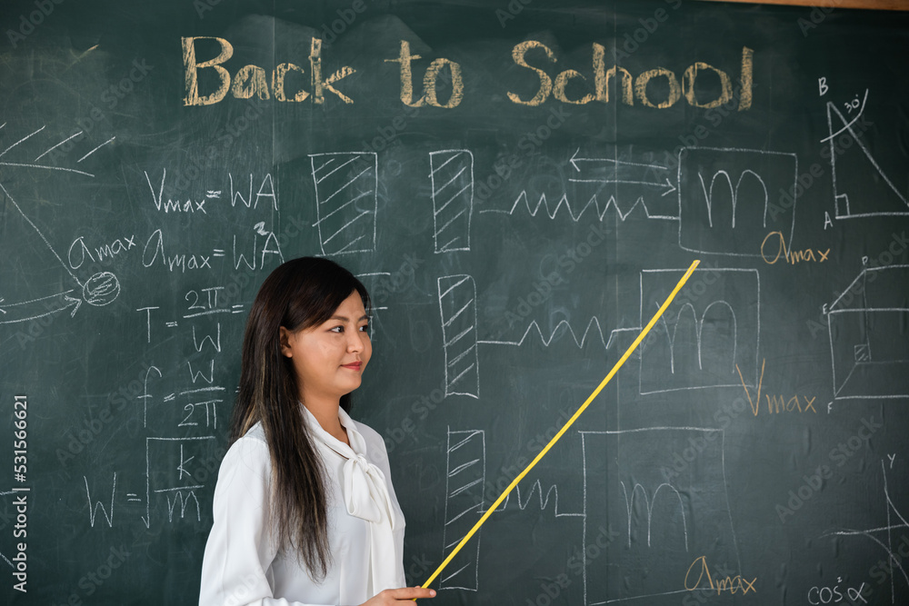 Back to school concept. Asian female teacher smiling with wooden stick ...