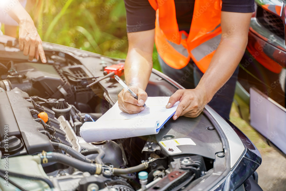 Closeup and crop auto repair checking engine and post a list of repairs ...