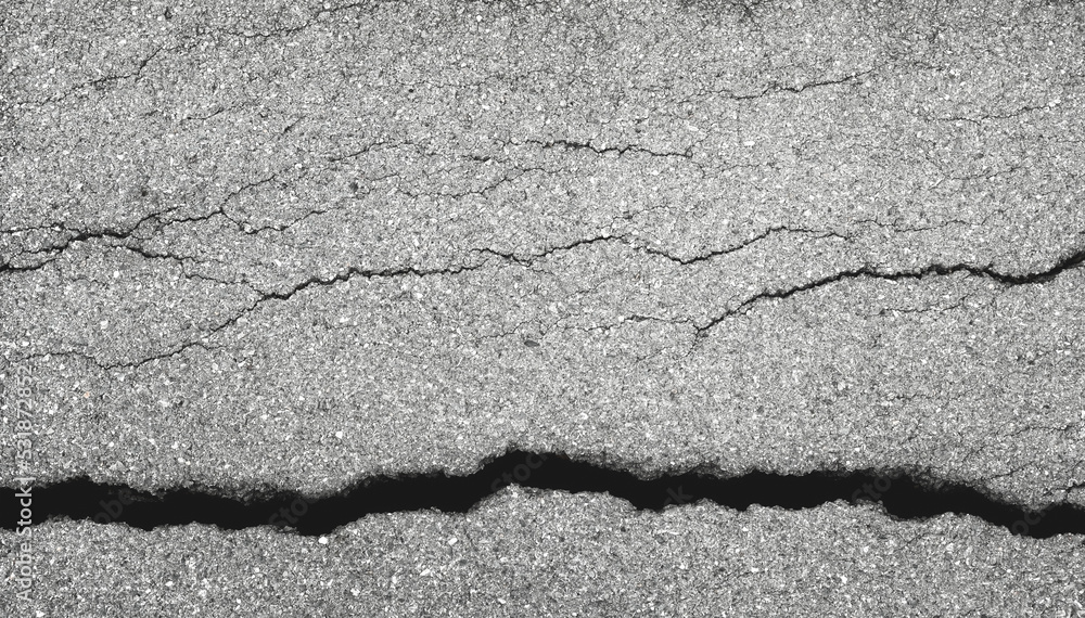 Earthquake disaster background. Cracks of road surface. Broken concrete ...