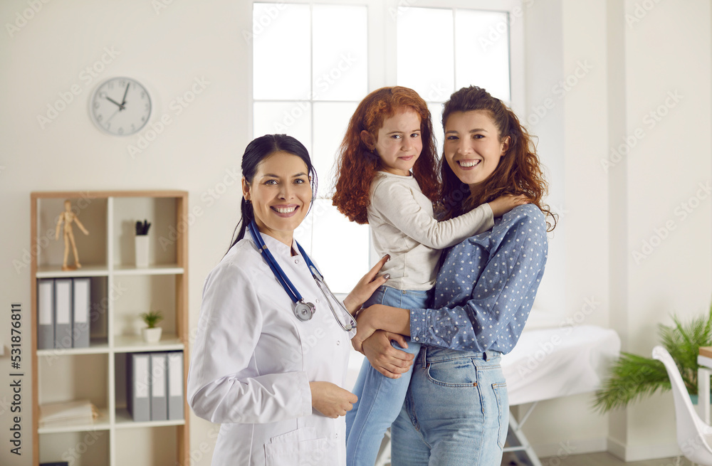 Portrait of cheerful family doctor with woman holding her little ...