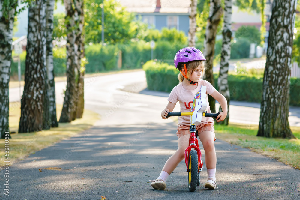 Little preschool girl with helmet running with balance bike on summer ...