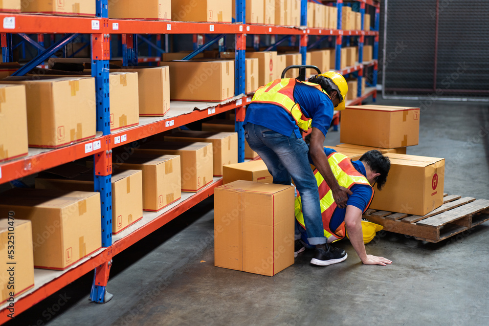 Warehouse factory worker helping to pick up colleague, Parcel box falls ...