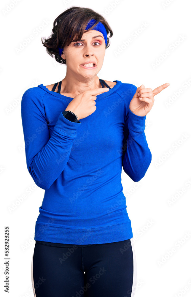 Beautiful young woman with short hair wearing training workout clothes ...