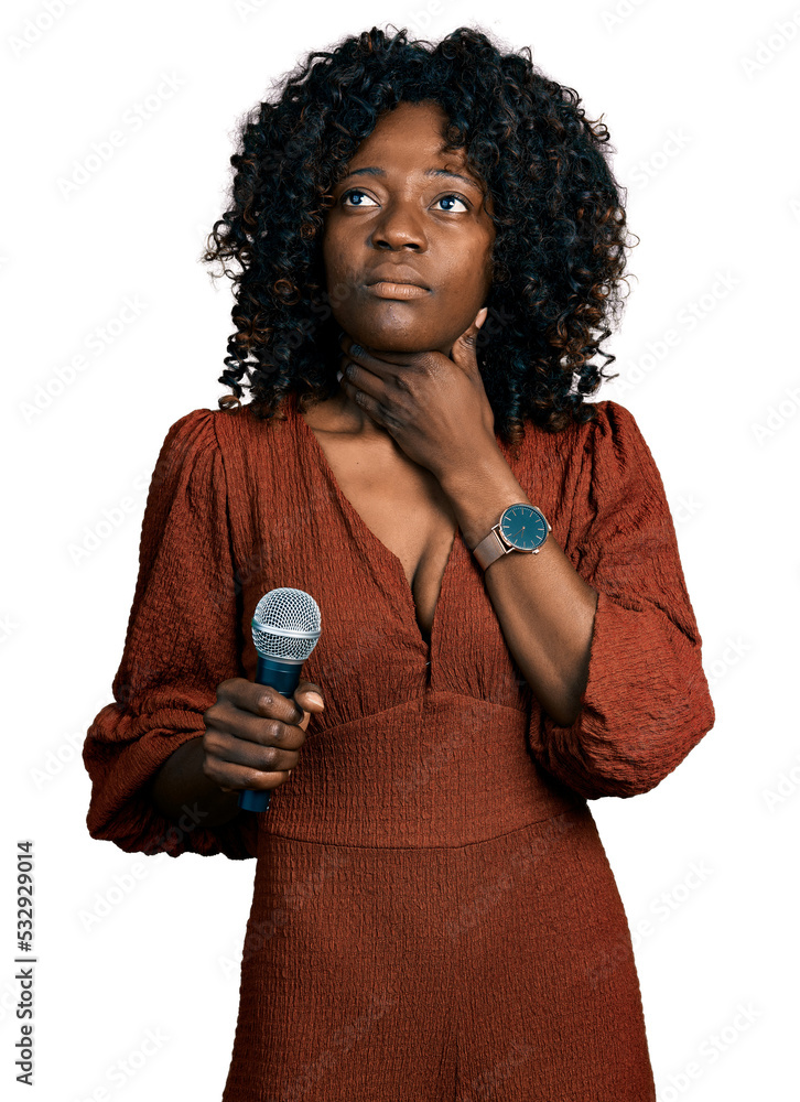 African woman with curly hair singing song using microphone touching ...