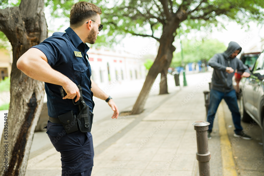 Cop getting ready to use his gun arresting a robber Stock Photo | Adobe ...