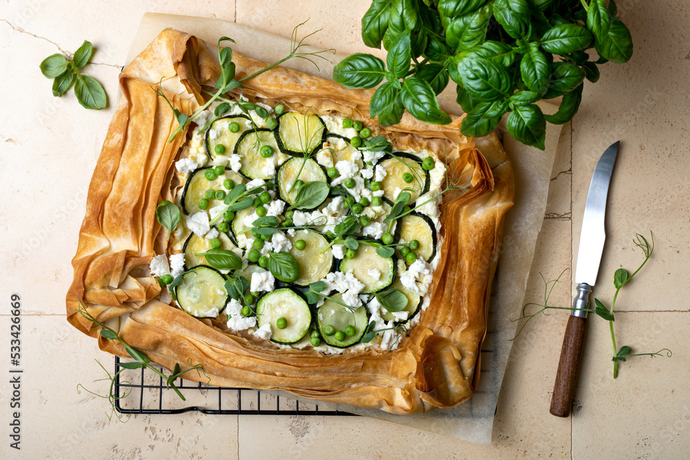 Zucchini and cheese phyllo dough tart with green peas, micro greens and ...