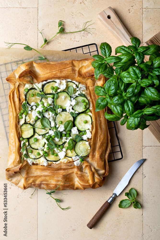 Zucchini and cheese phyllo dough tart with green peas, micro greens and ...