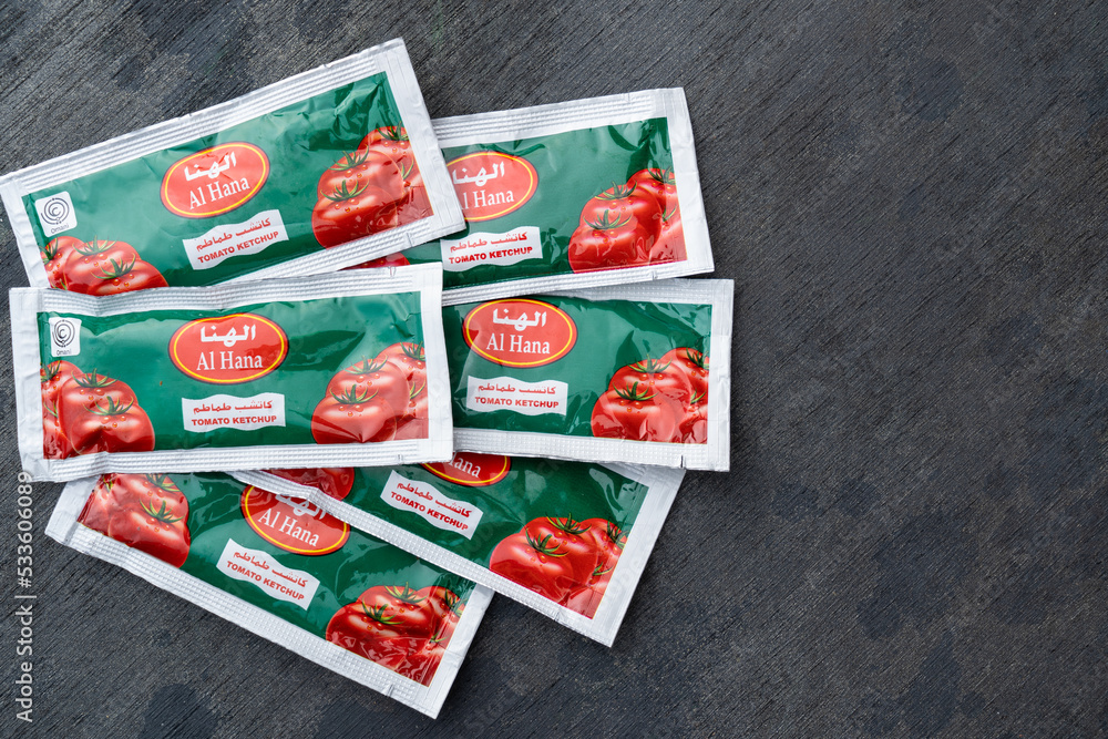 Packets of single serving Al Hana Tomato Ketchup on wooden background ...
