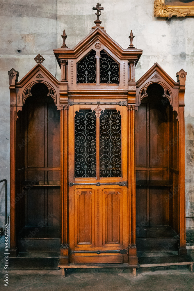 Antique wooden confessional box in dark wood in a church. Religious ...