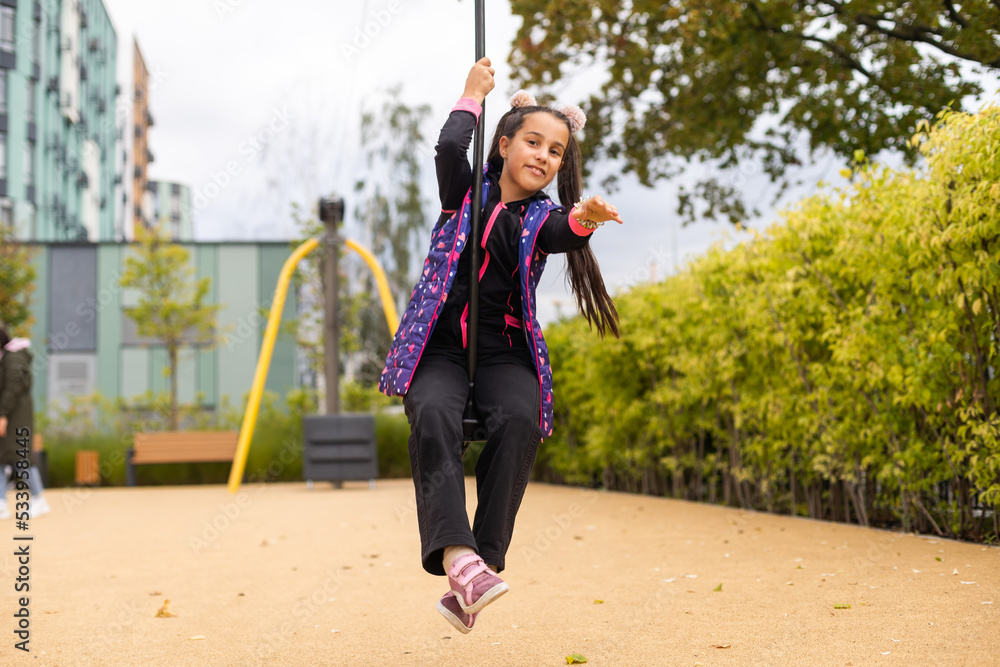 Photo Stock Little girl rides on Flying Fox play equipment. Child girl ...