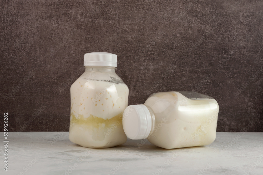 Spoiled dairy products in disposable plastic bottles. Bloated swollen ...