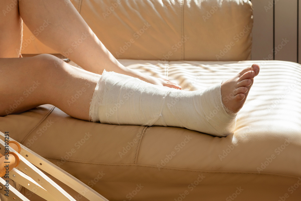 Girl with a cast on their leg, sitting on the couch and drawing on a ...