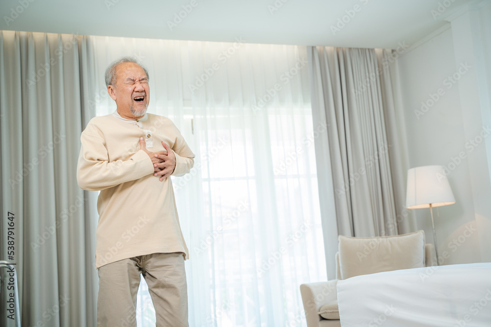 Asian senior man having heart attack and falling on the ground while ...