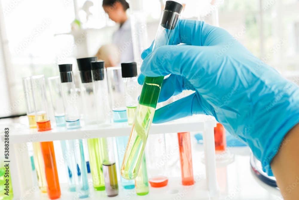 Scientist holding tubes. Many test tubes in the laboratory with ...