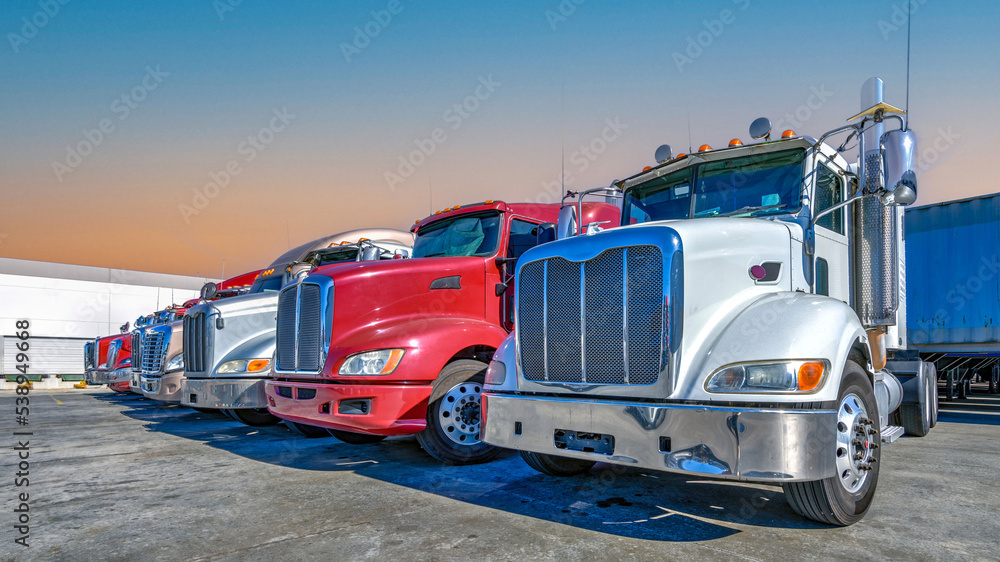 Lined up Semi truck heads on a parking lot at logistics warehouse ...