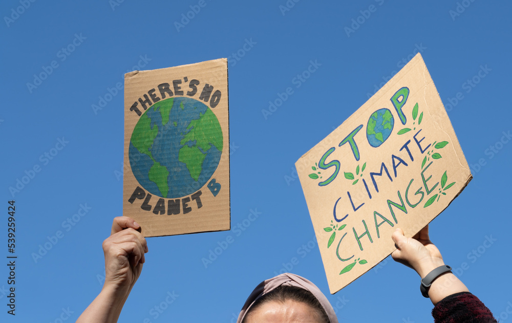 Protesters holding signs with slogans There's no planet B and Stop ...