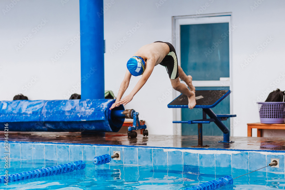 latin teenager man swimmer athlete wearing cap and goggles in a ...