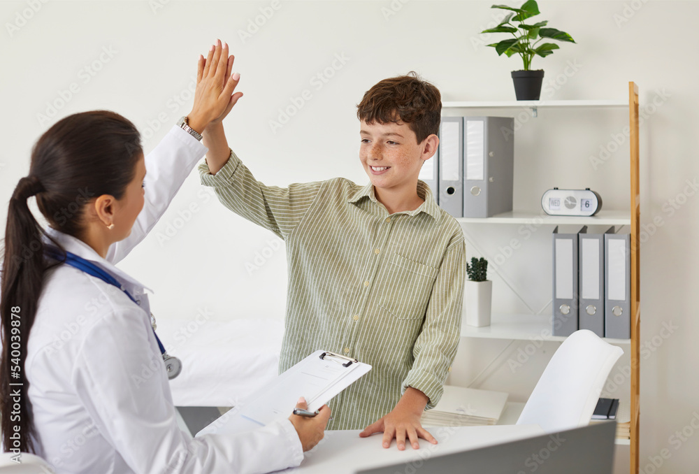 Happy friendly doctor and child patient give each other high five after ...