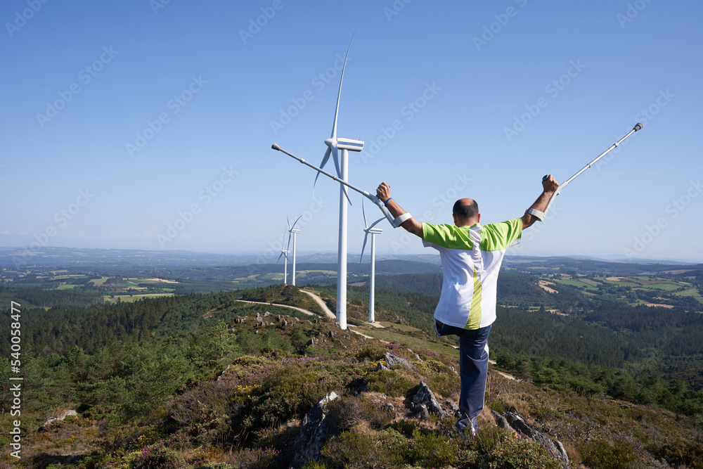 The unrecognizable man balances on his one leg raising his crutches as ...