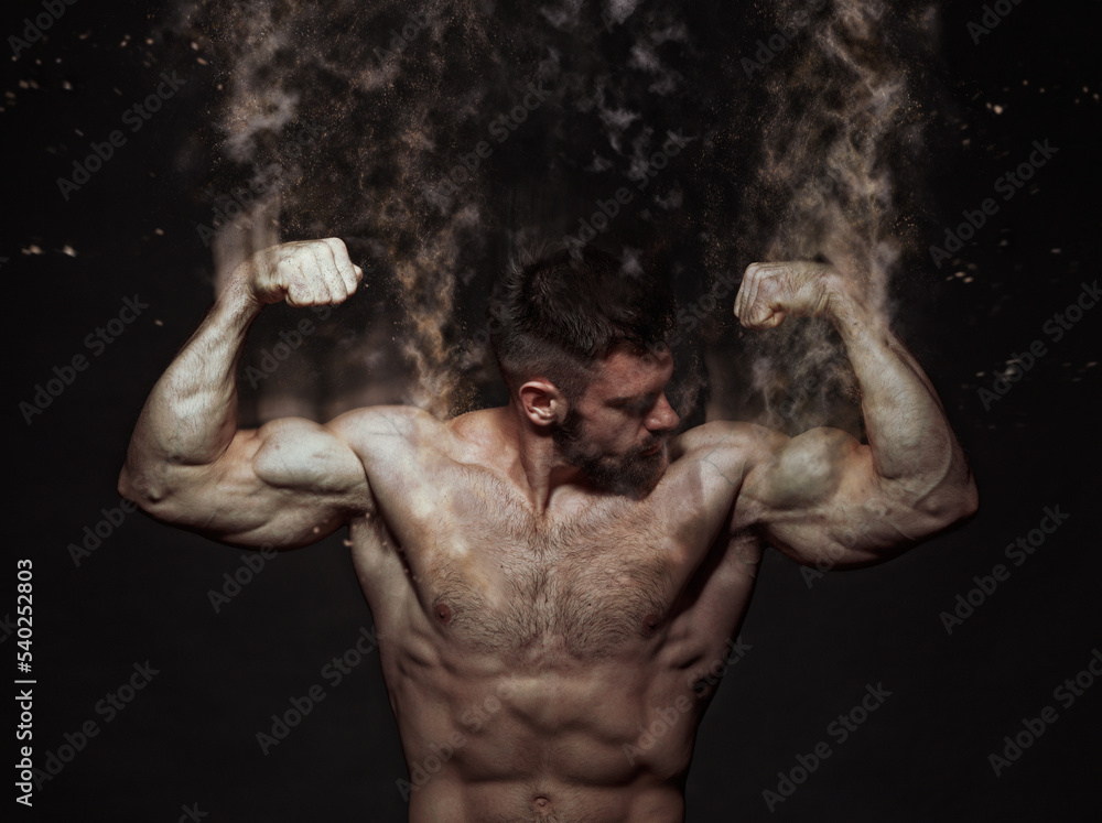 Muscle shirtless bodybuilder flexing his biceps, disintegrating into ...