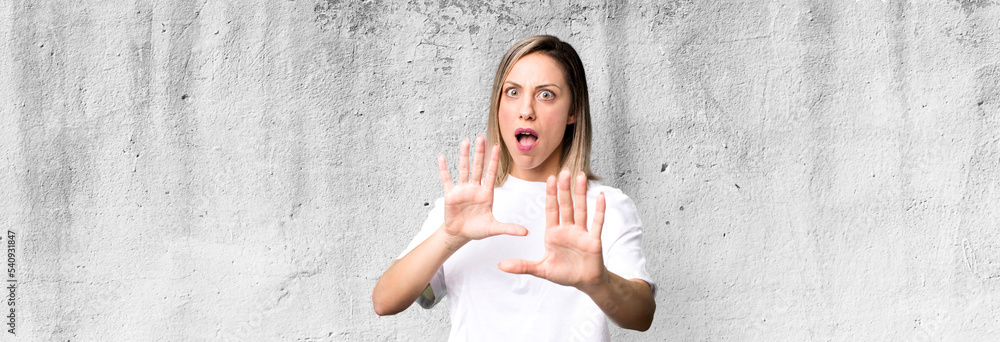 blonde adult woman feeling terrified, backing off and screaming in ...