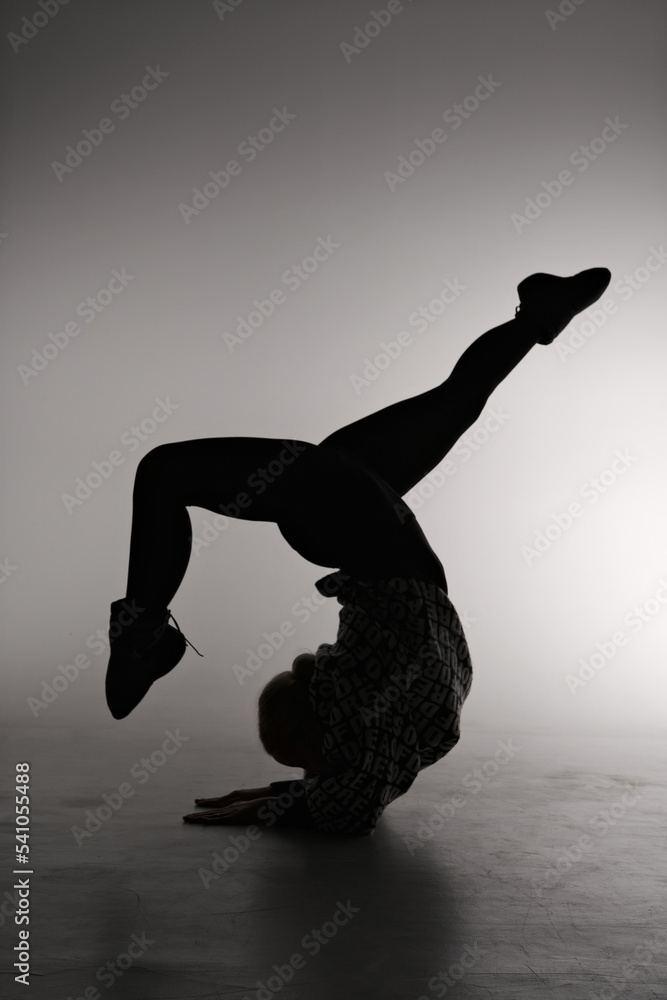 young ballet dancer posing on a grey background. Ballerina is wearing ...