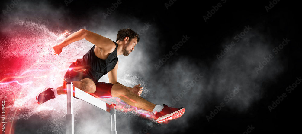 Man athlete at hurdle race, jumping over the last hurdle Stock Photo ...