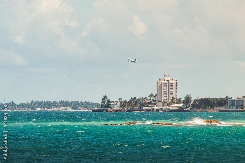Beautiful condado city beach landscape with airplane flying from puerto ...