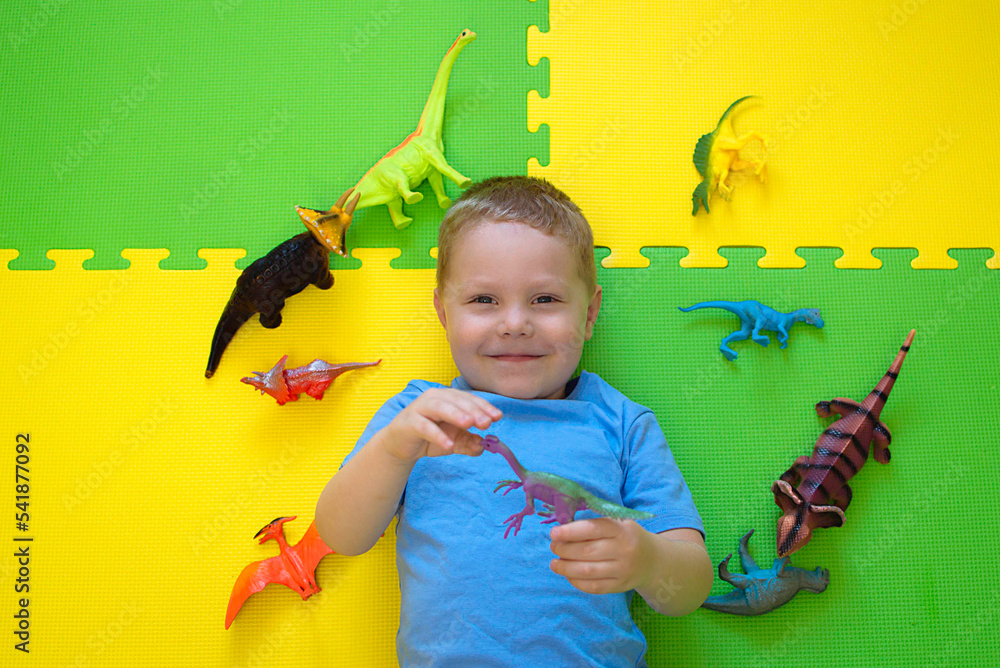 Children's toys. A little boy is playing at home with toy figures of ...