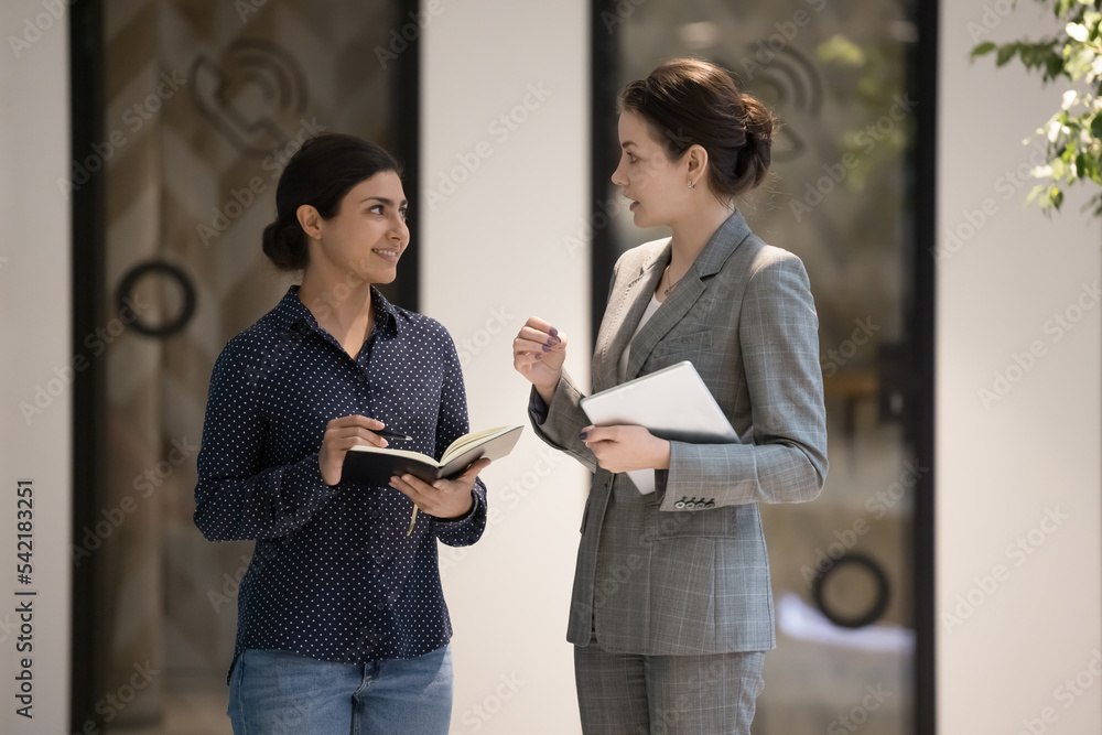 Businesswomen stand in office hallway and talking, boss gives task to ...