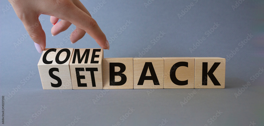 Comeback and setback symbol. Hand turns a cube and changes the word ...