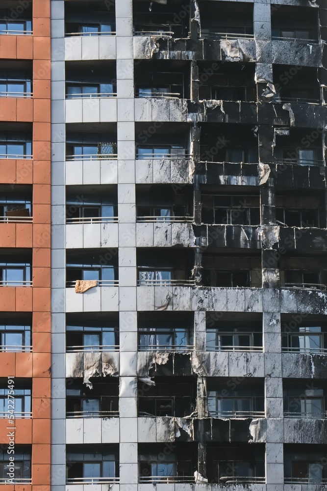 Ruined charred burnt residential high-rise building wall after fire ...