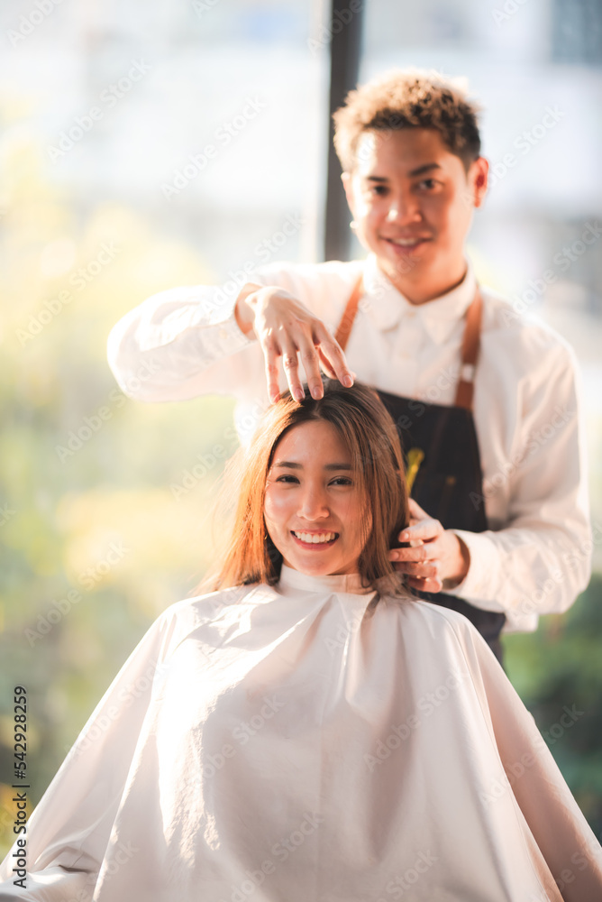 Young beautiful and smiling Asian woman sitting in salon chair against ...