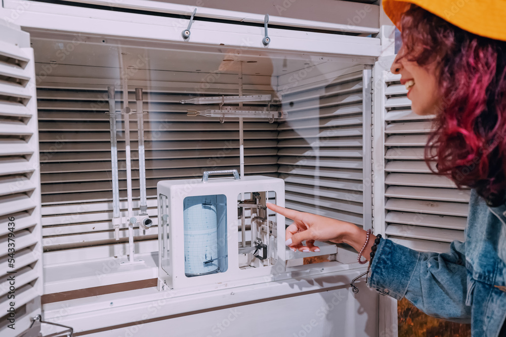 Girl student exploring weather station with barometer, thermometer and ...