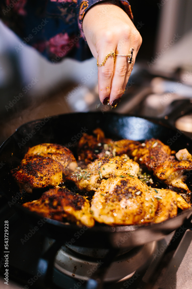 organic chicken thighs cooking in a cast iron skillet の Stock フォト ...