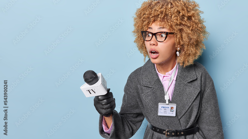 Shocked female journalist looks stunned aside holds microphone ...