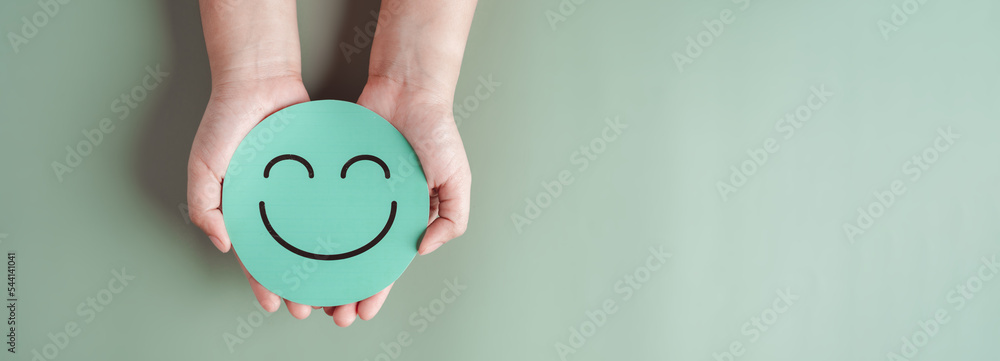 Hands holding green happy smile face, good feedback rating, positive ...