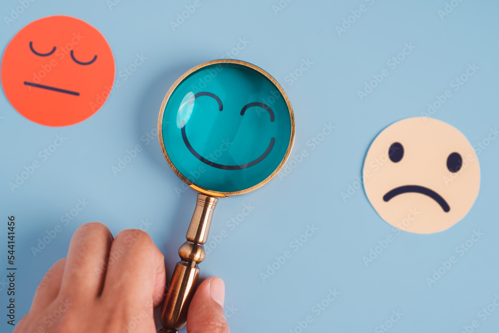 Hand holding magnifier focus selected happy smiley face paper cut which ...