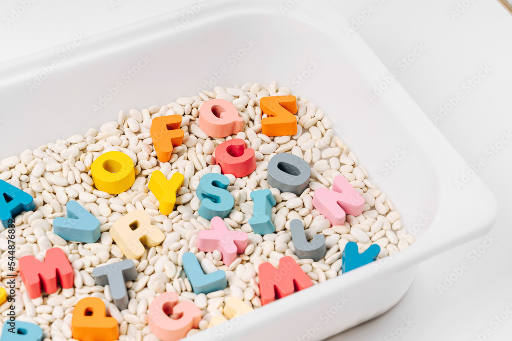 Colorful letters of the alphabet in sensory bin. Primary school or ...