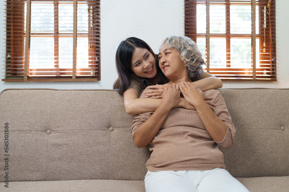 Asian family mother daughter give hug cuddle embrace at home sofa, Grown up daughter hugging ...