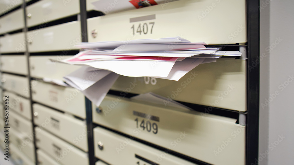 Mailboxes filled with letters and bills in an apartment building. An ...