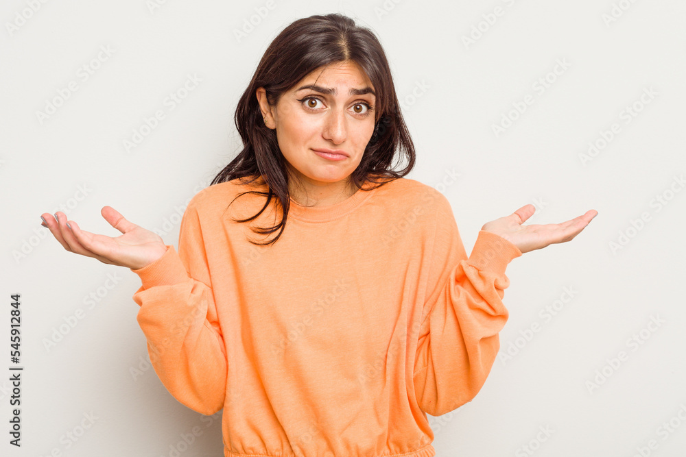 Young Indian woman isolated on white background doubting and shrugging ...