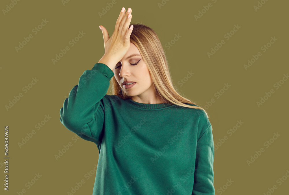 Forgetful young woman taps her forehead with her hand, remembering ...