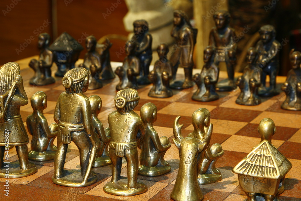 Metal crafted chess pieces on a leather board showing Filipino ...
