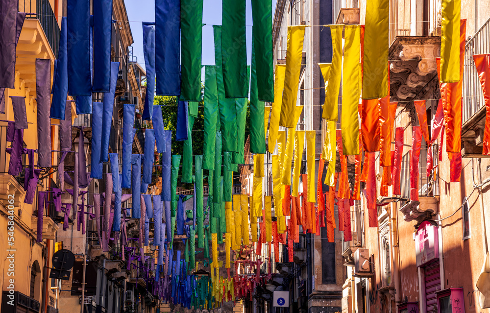 european street, decorated with hanged colorful ribbons in lgbt flag ...