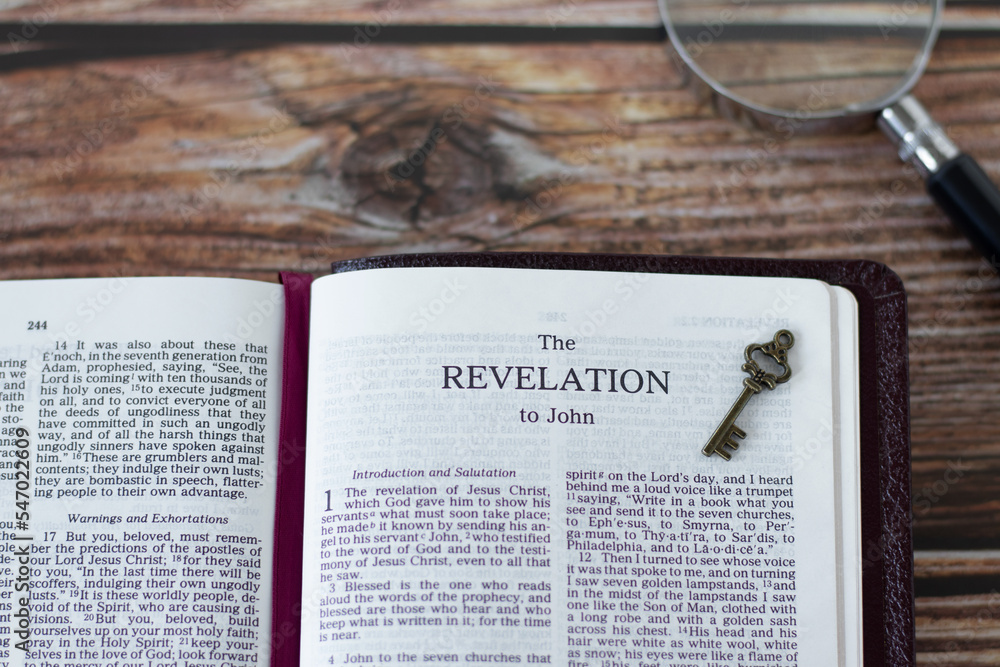Revelation Bible Book with ancient key and magnifying glass on wooden ...