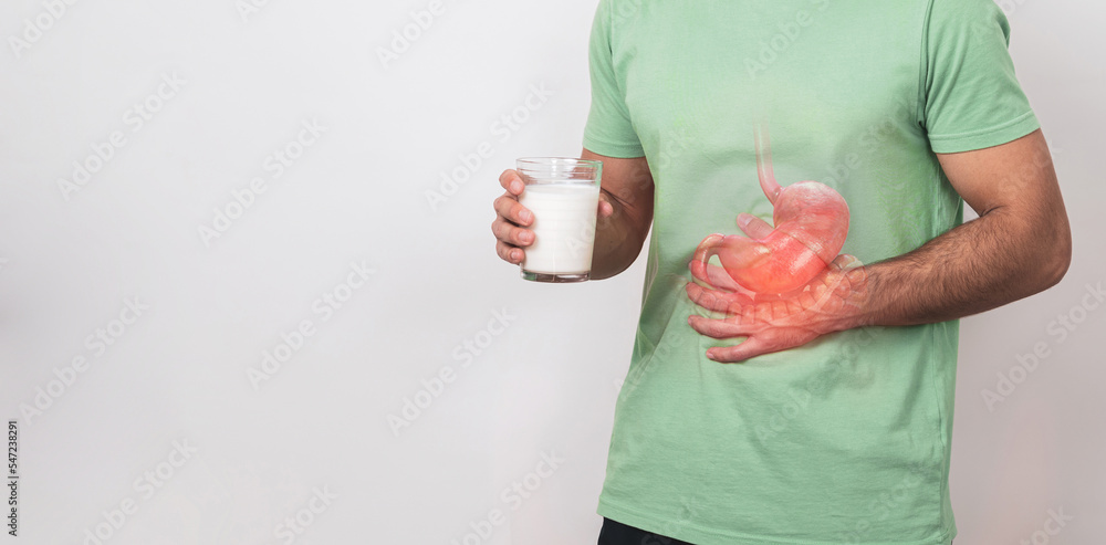 Lactose intolerance. An unrecognizable young man holds a glass of milk ...