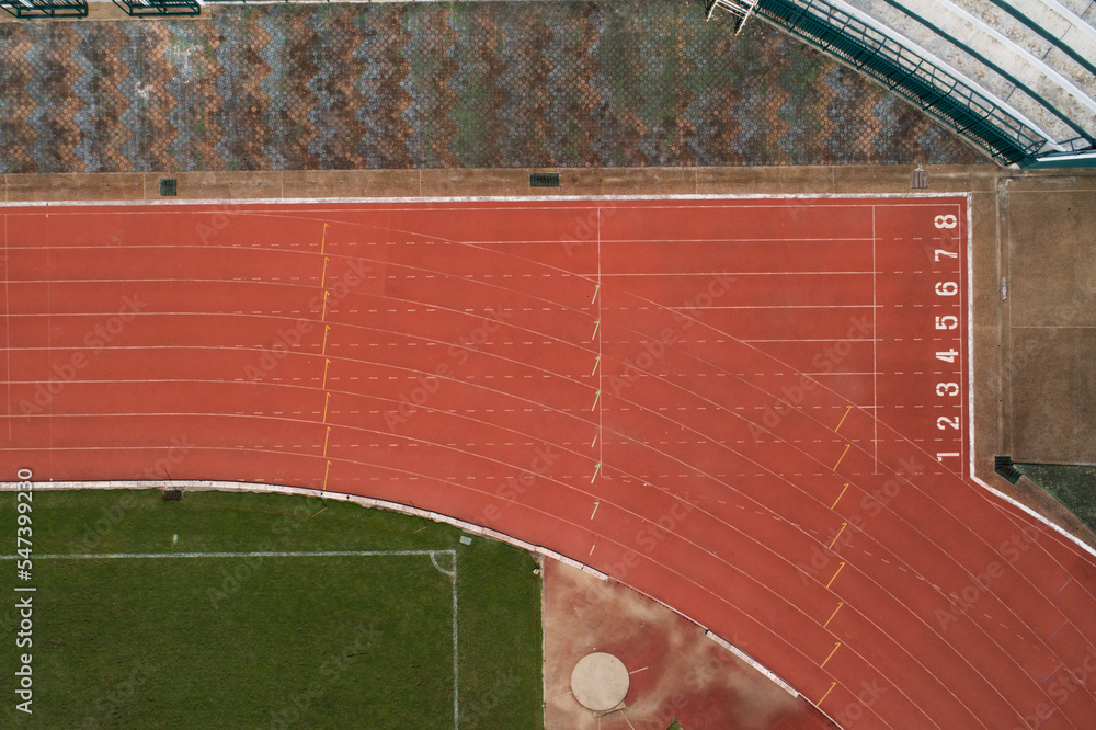 Aerial view of empty soccer field from above with running tracks around ...