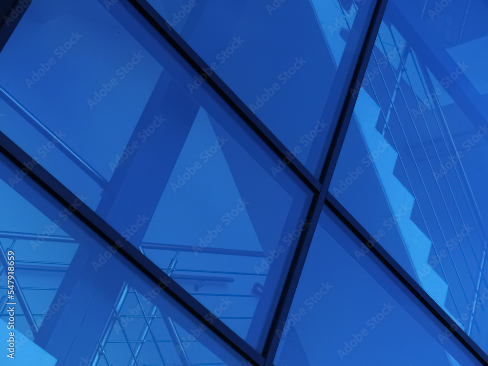 Stairs behind the blue glass panels of the facade of a modern building ...
