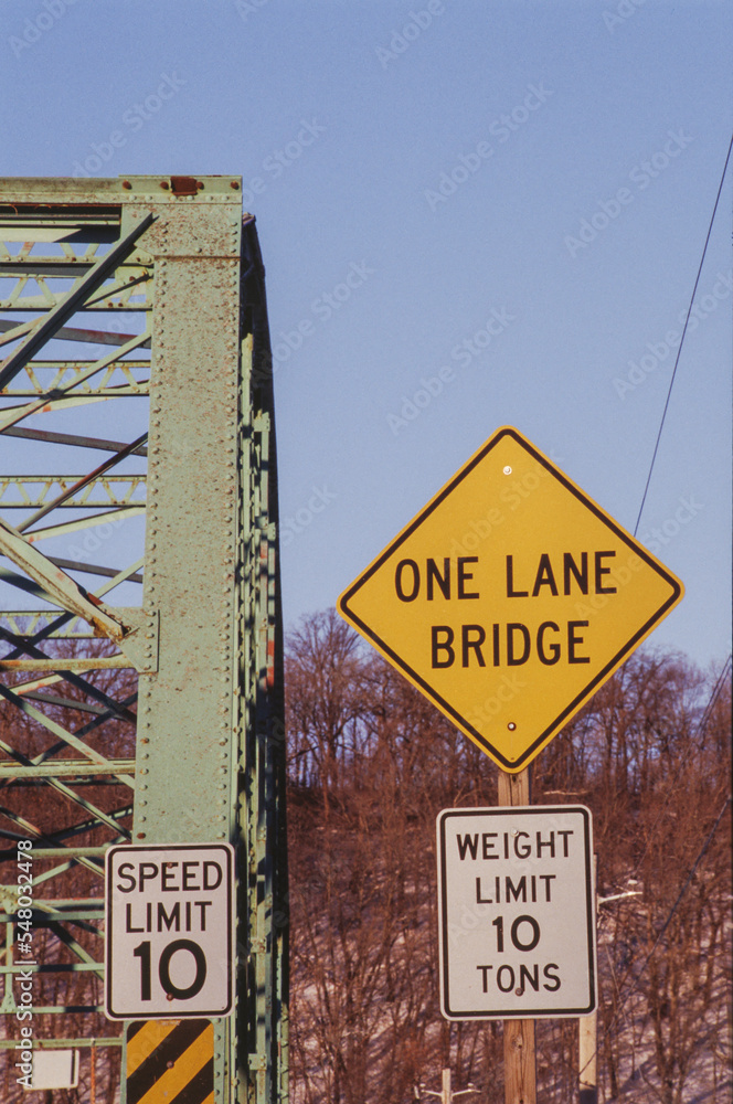 Foto de Stock One lane bridge speed limit, and weight limit signs on ...